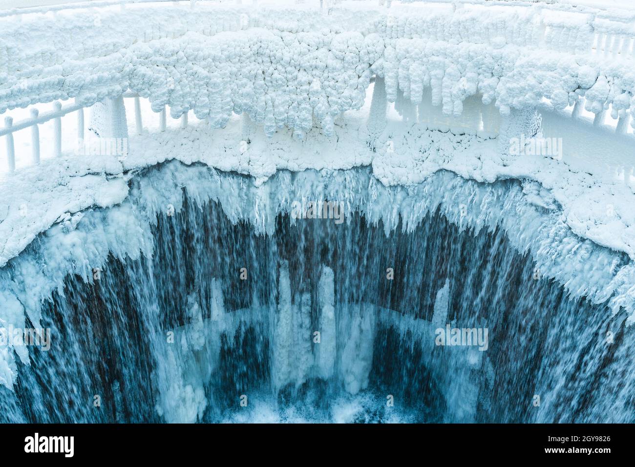 Frozen waterfall flowing through a small dam. Winter background Stock ...