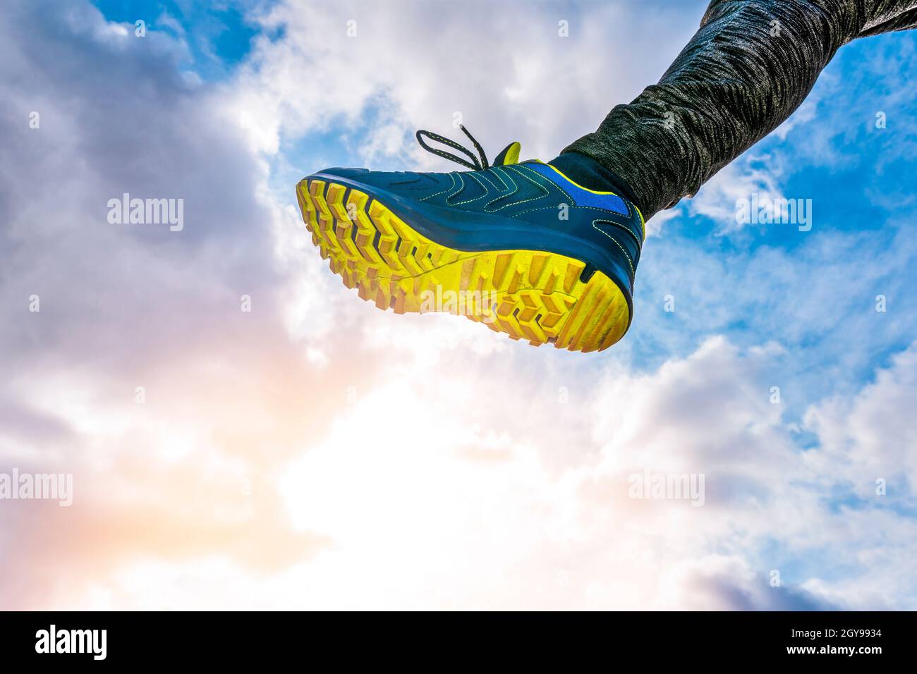 Running and jumping over the camera. Running shoe on sky background ...