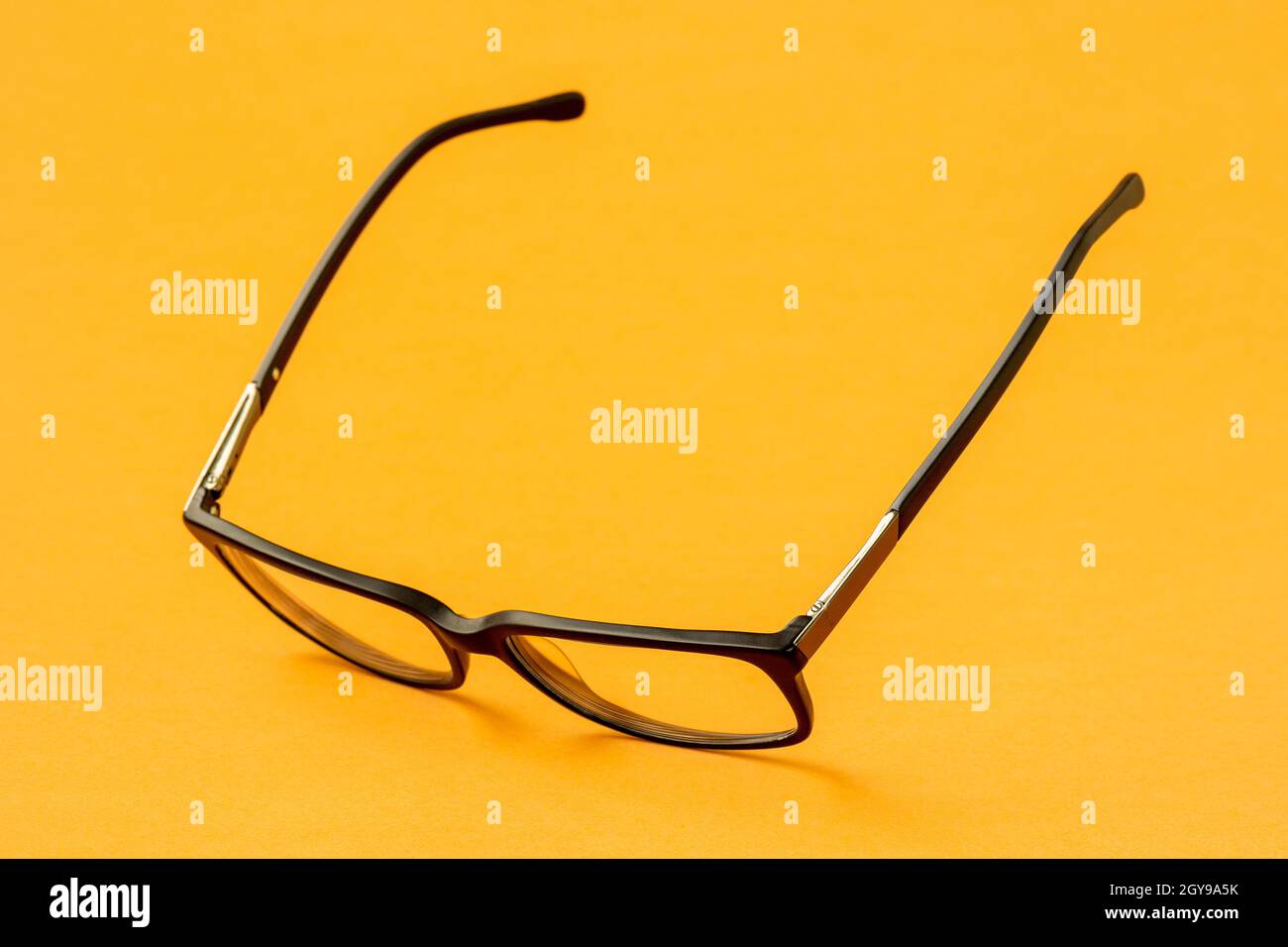 Eyeglasses with black frame on yellow background. Ophthalmology theme ...
