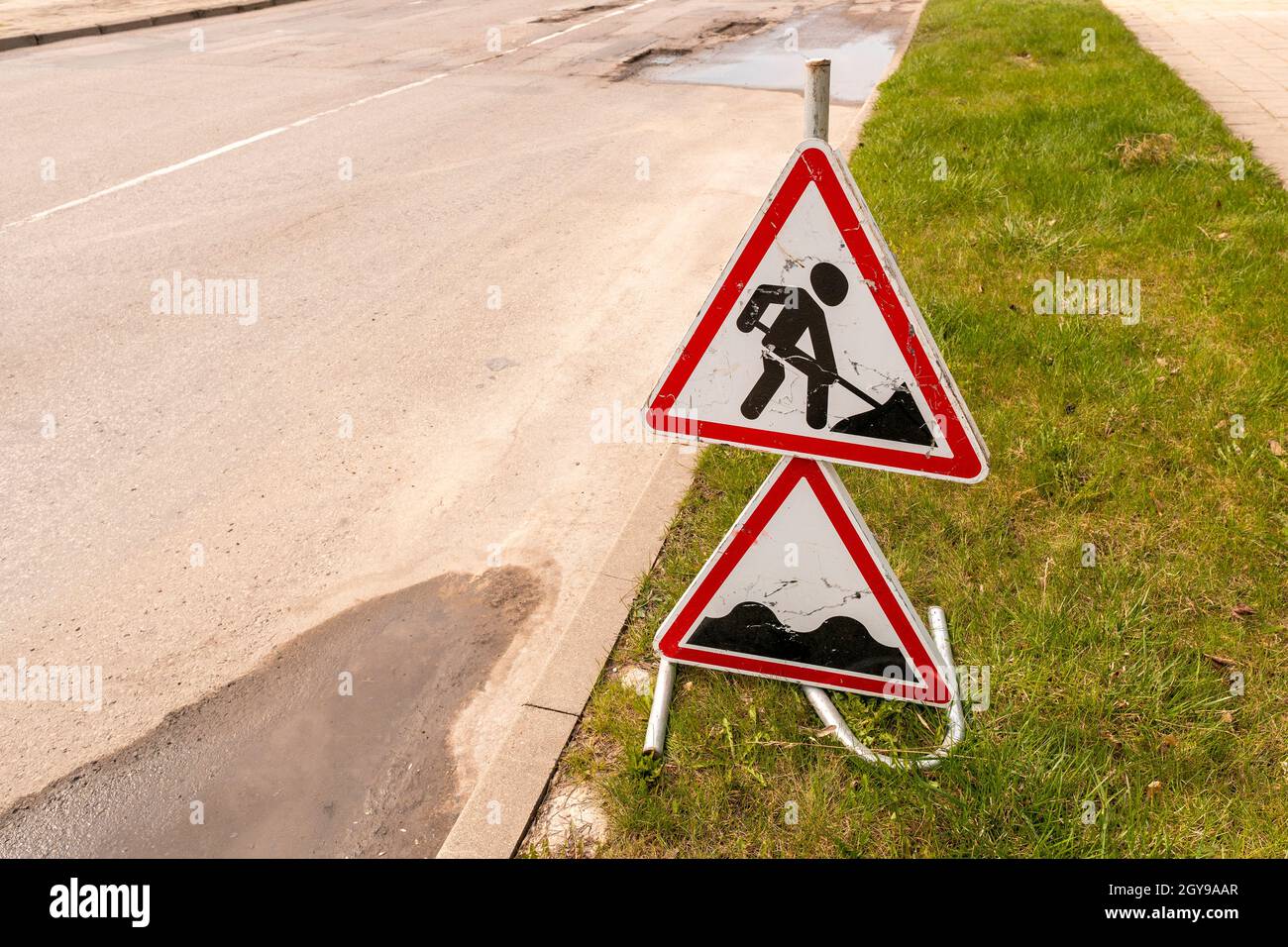 Road Works Ahead Warning Road Sign.Damaged asphalt road. Repair of ...