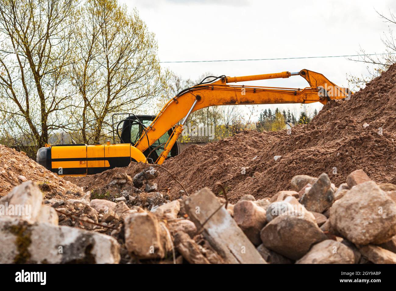 Recycling concrete and construction waste from demolition. Excavator at ...