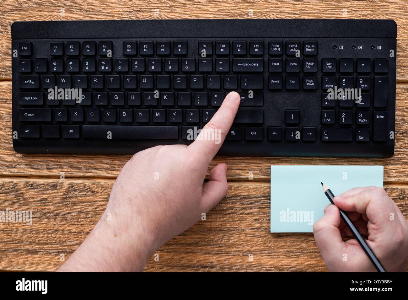 Hands Pressing Computer Keyboard Keys While Writing With Pencil In ...