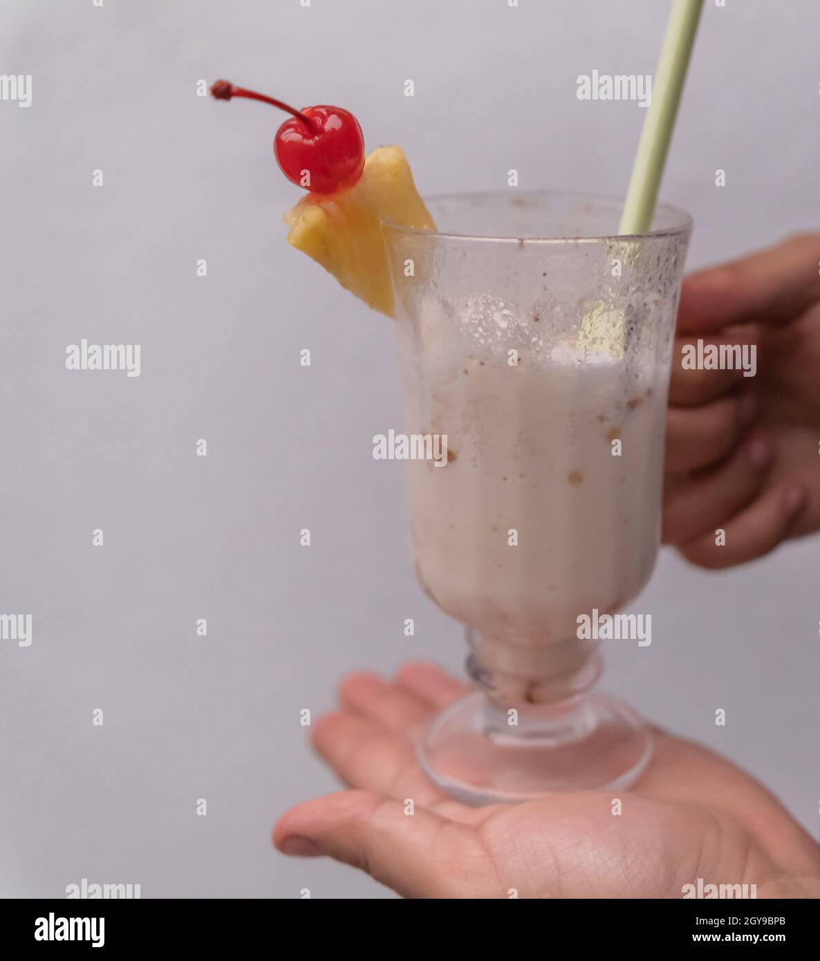 Male hands holding tasty vanilla milkshake with gray background Stock ...