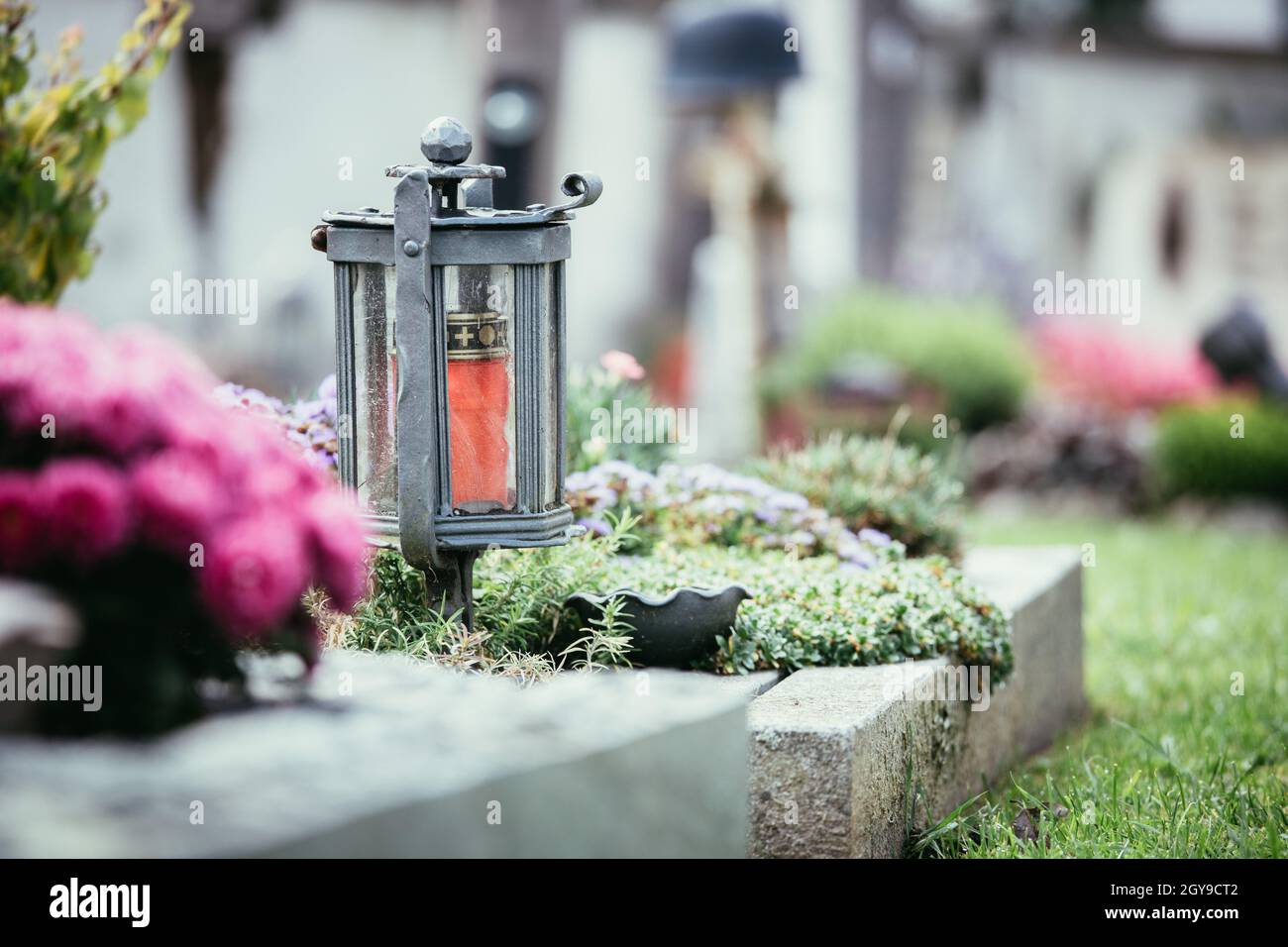 Candle in an iron lantern on a grave at a cemetery Stock Photo - Alamy