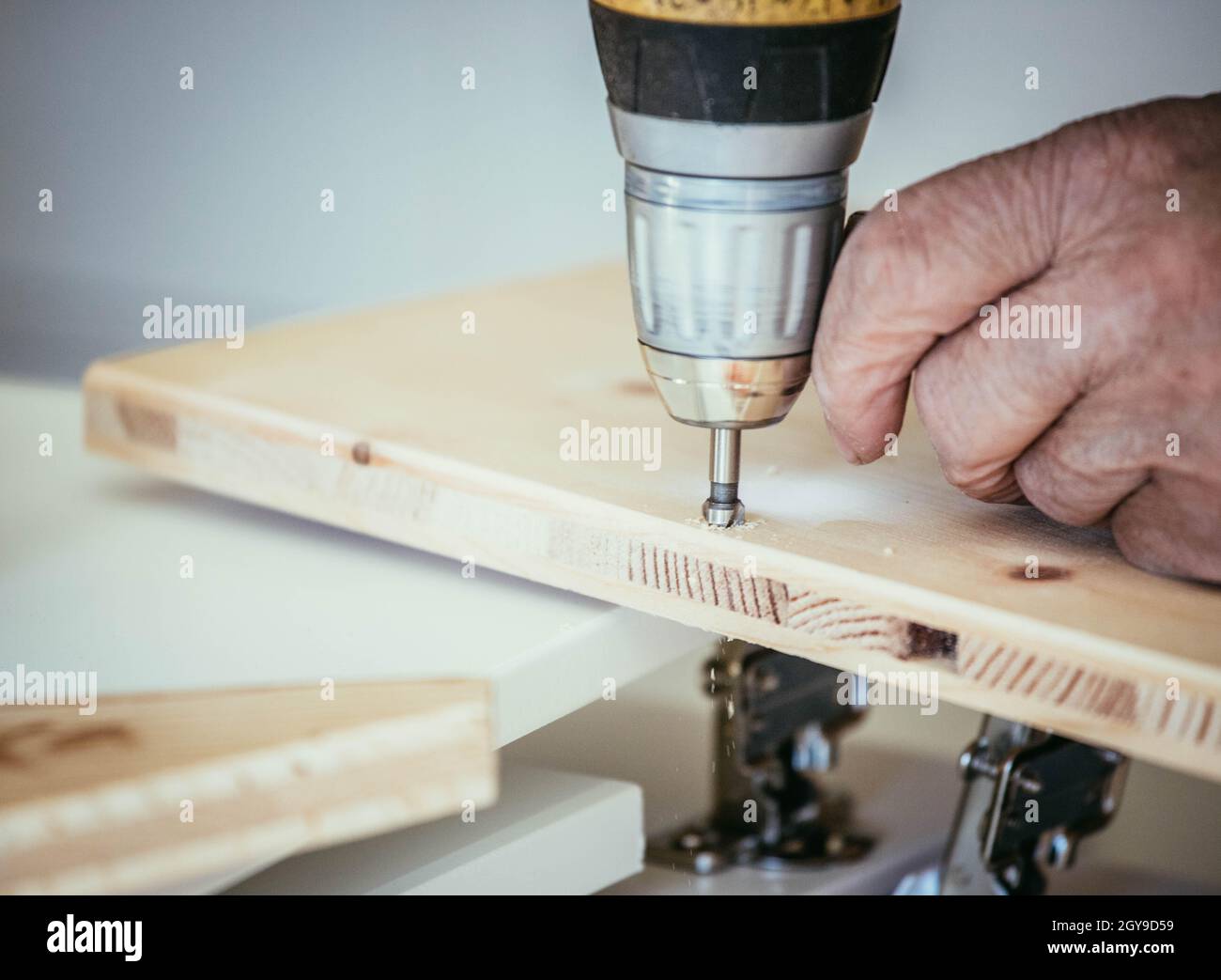 Craftsman is drilling in wood with drilling machine Stock Photo - Alamy