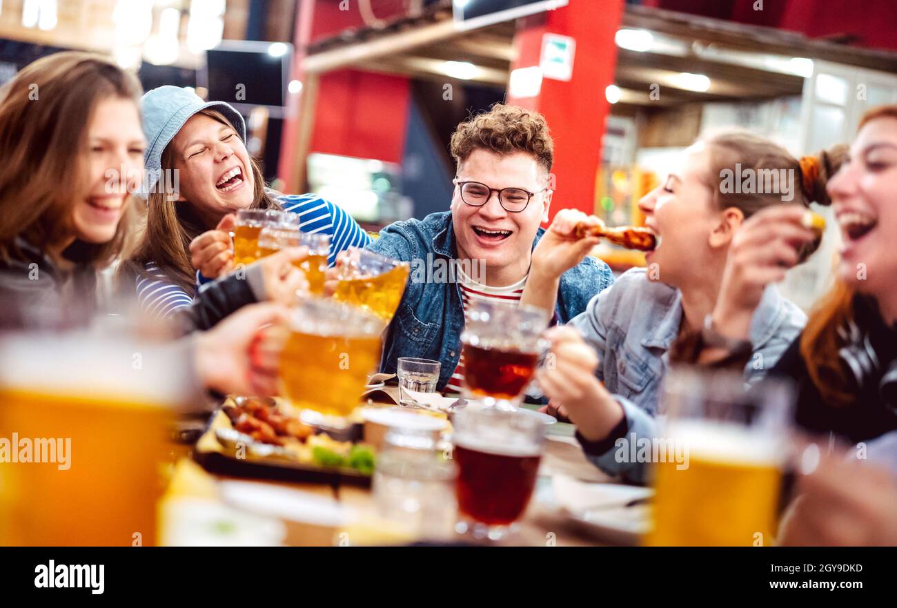 Happy friends drinking beer with mixed food at indoor venue - Social ...