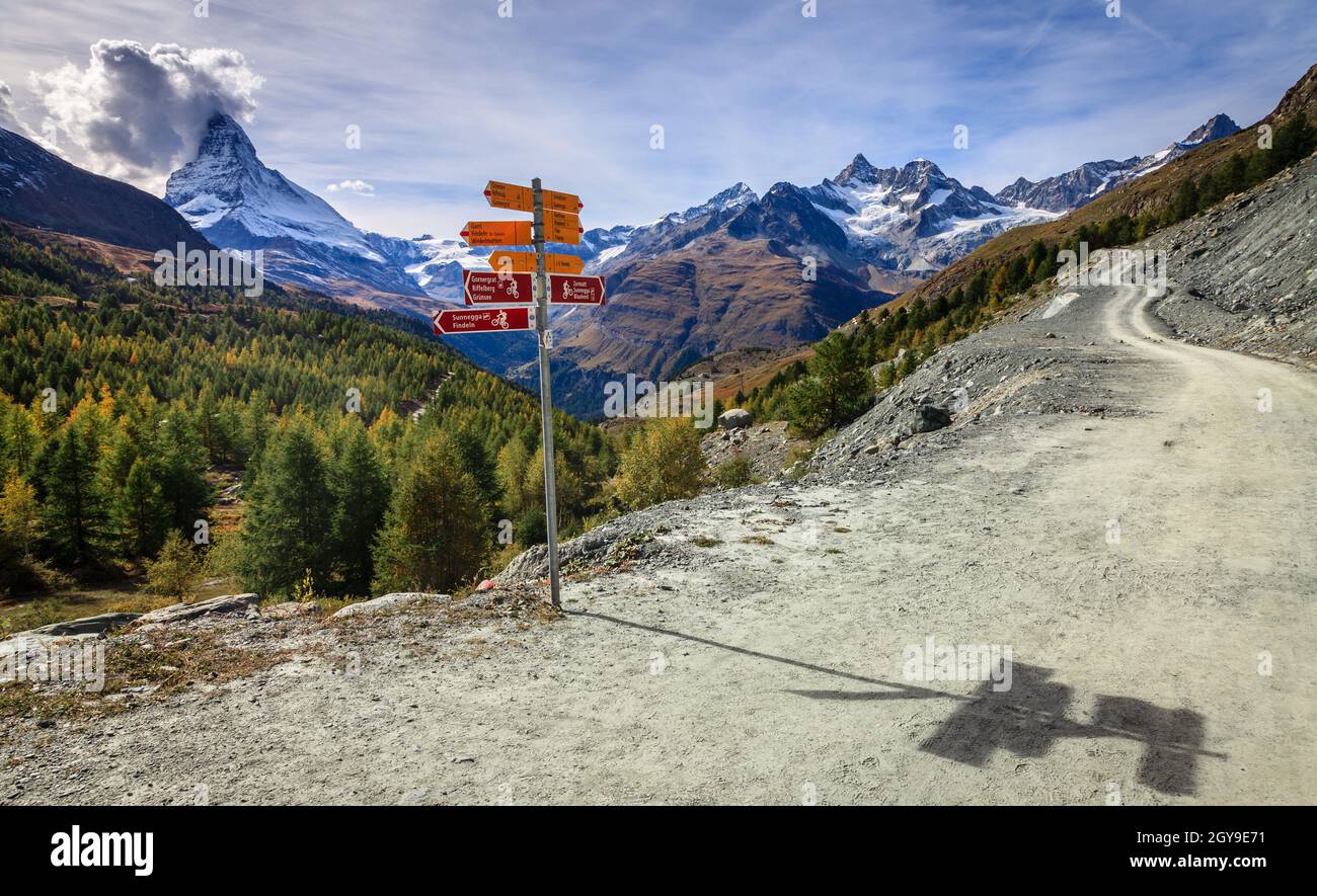 Gravel road and a sign in the mountains near Zermatt with Matterhorn in ...