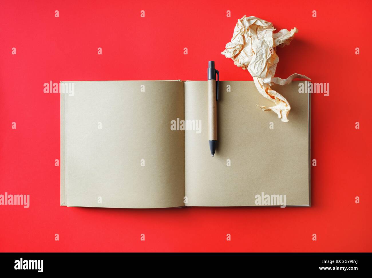 Photo of kraft open book with blank pages, crumpled paper and pen on ...