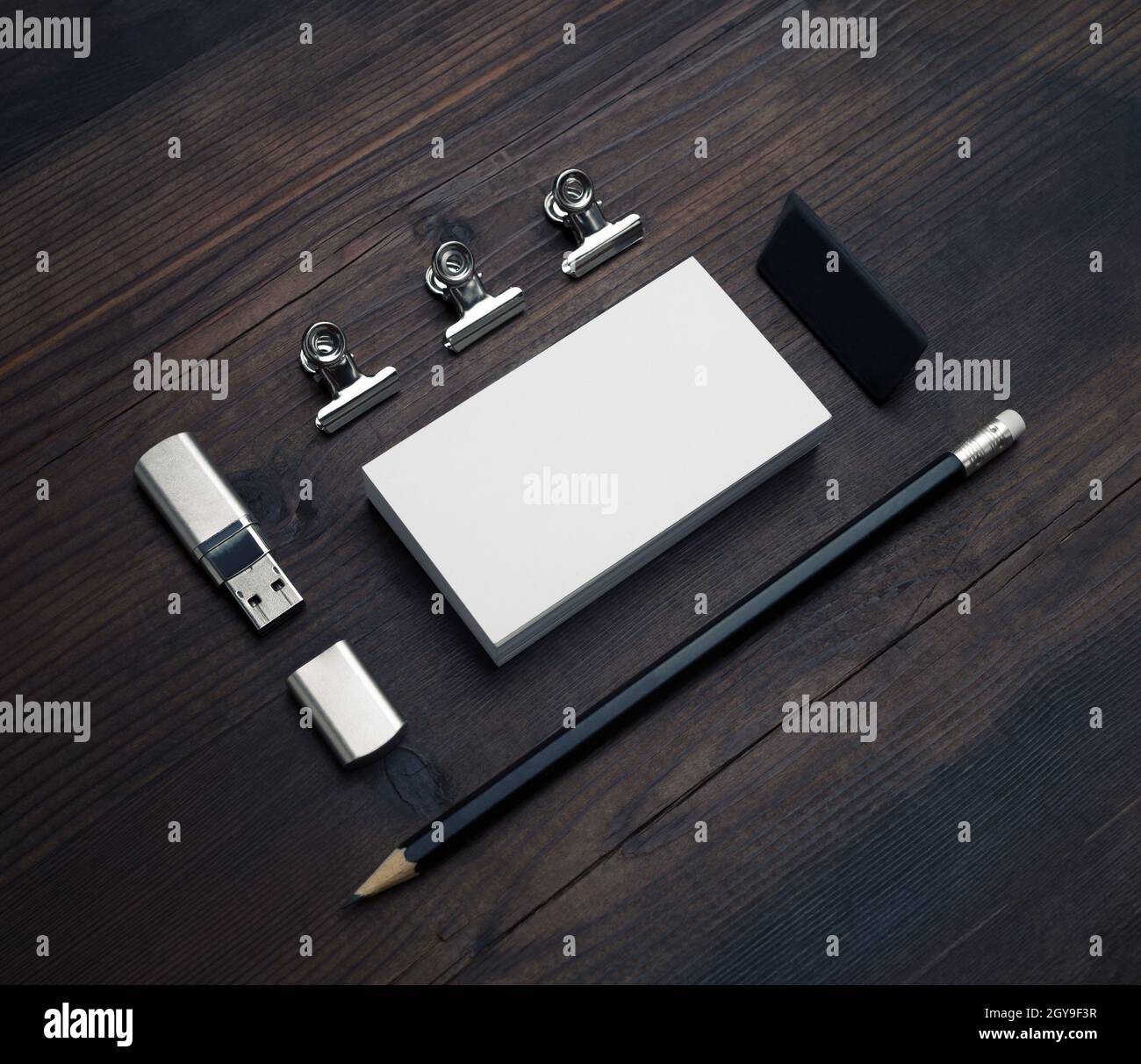 Blank business card, flash drive, pencil and eraser on wood table ...