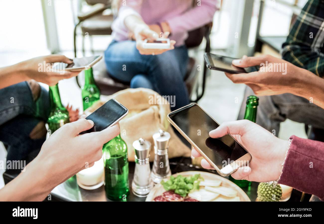 Group of multicultural friends having fun on smartphone at bar - People ...