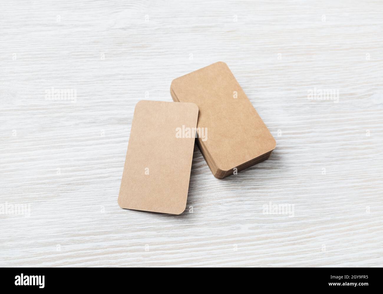 Photo of blank kraft business cards on light wooden background ...