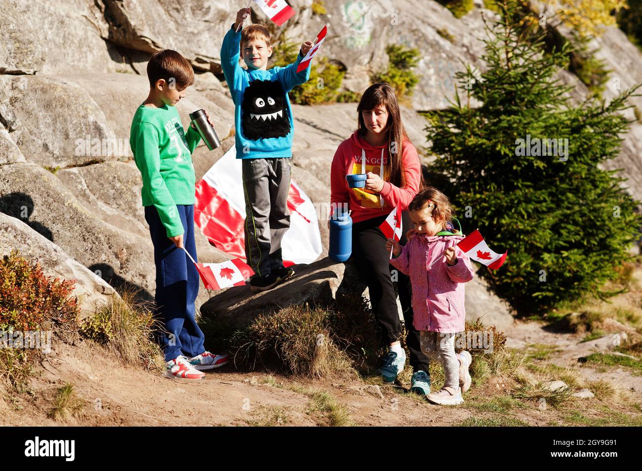 Happy Canada Day. Family of mother with three kids hold large Canadian ...