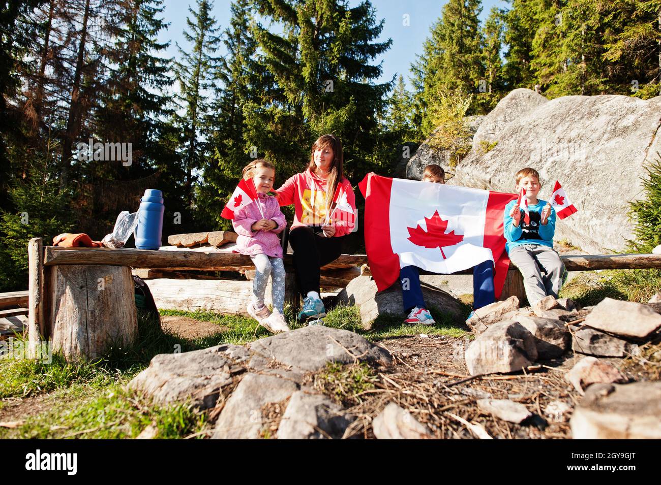 Happy Canada Day. Family of mother with three kids hold large Canadian ...