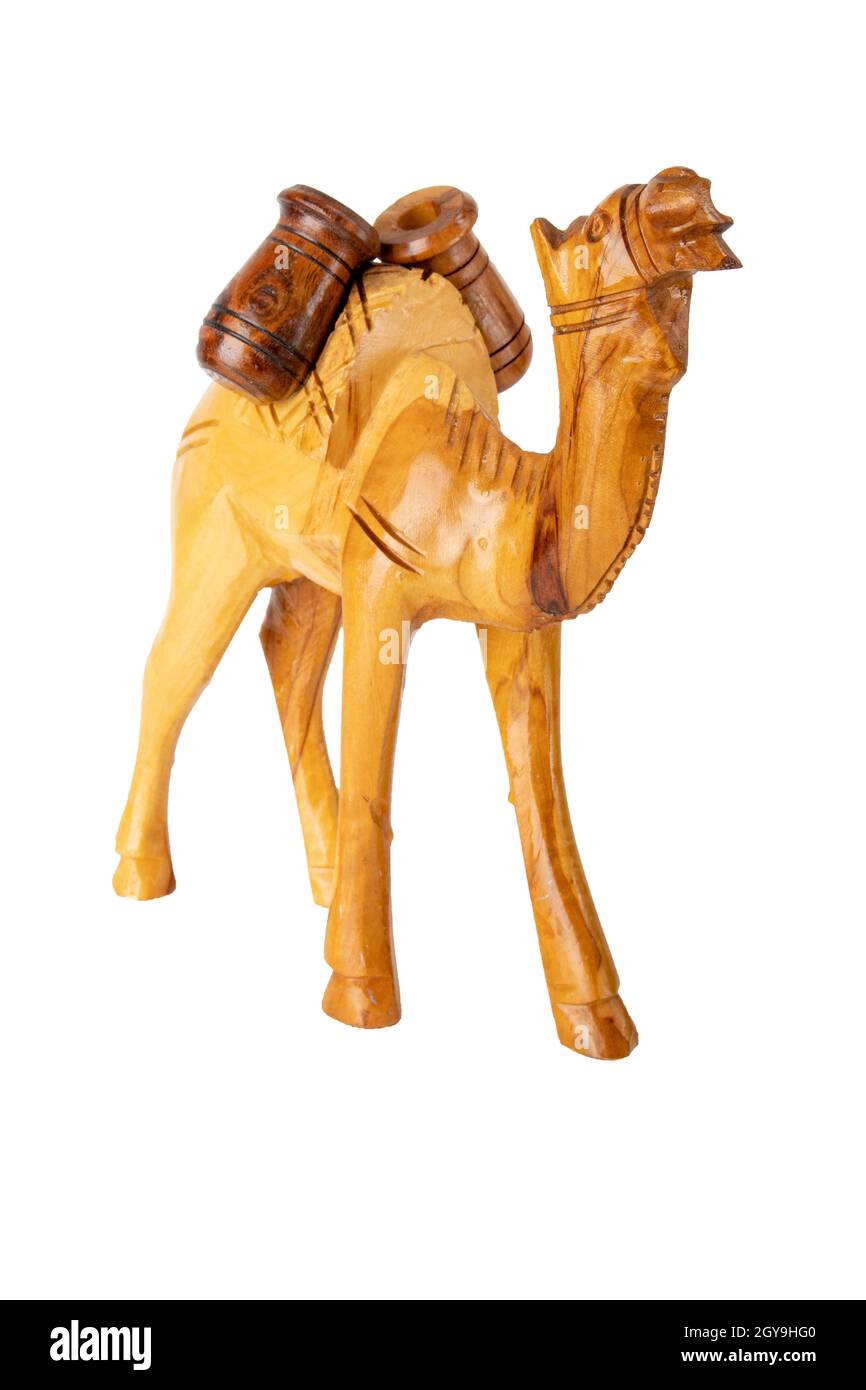 Closeup of a wooden handmade carved camel carrying two barrels isolated ...