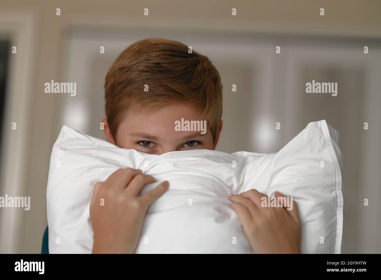 Portrait of adorable young boy hiding behind cushions. Family, vacation ...