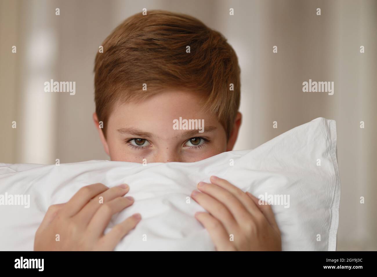 Portrait of adorable young boy hiding behind cushions. Family, vacation ...