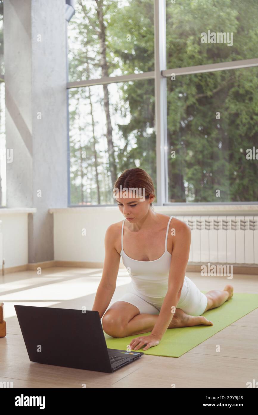 Young fit woman in sportswear watching online video with fitness ...