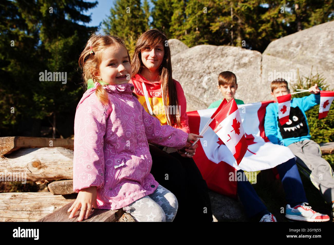 Happy Canada Day. Family of mother with three kids hold large Canadian ...
