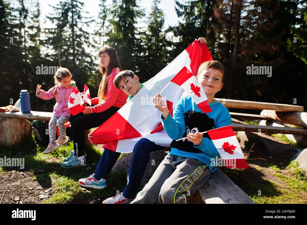 Happy Canada Day. Family of mother with three kids hold large Canadian ...
