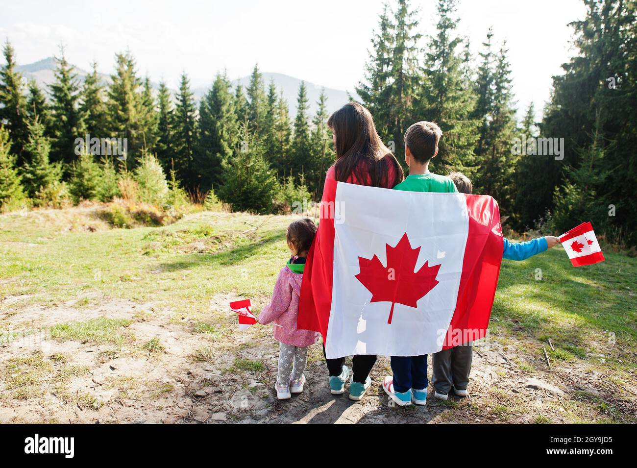 Happy Canada Day. Family of mother with three kids hold large Canadian ...