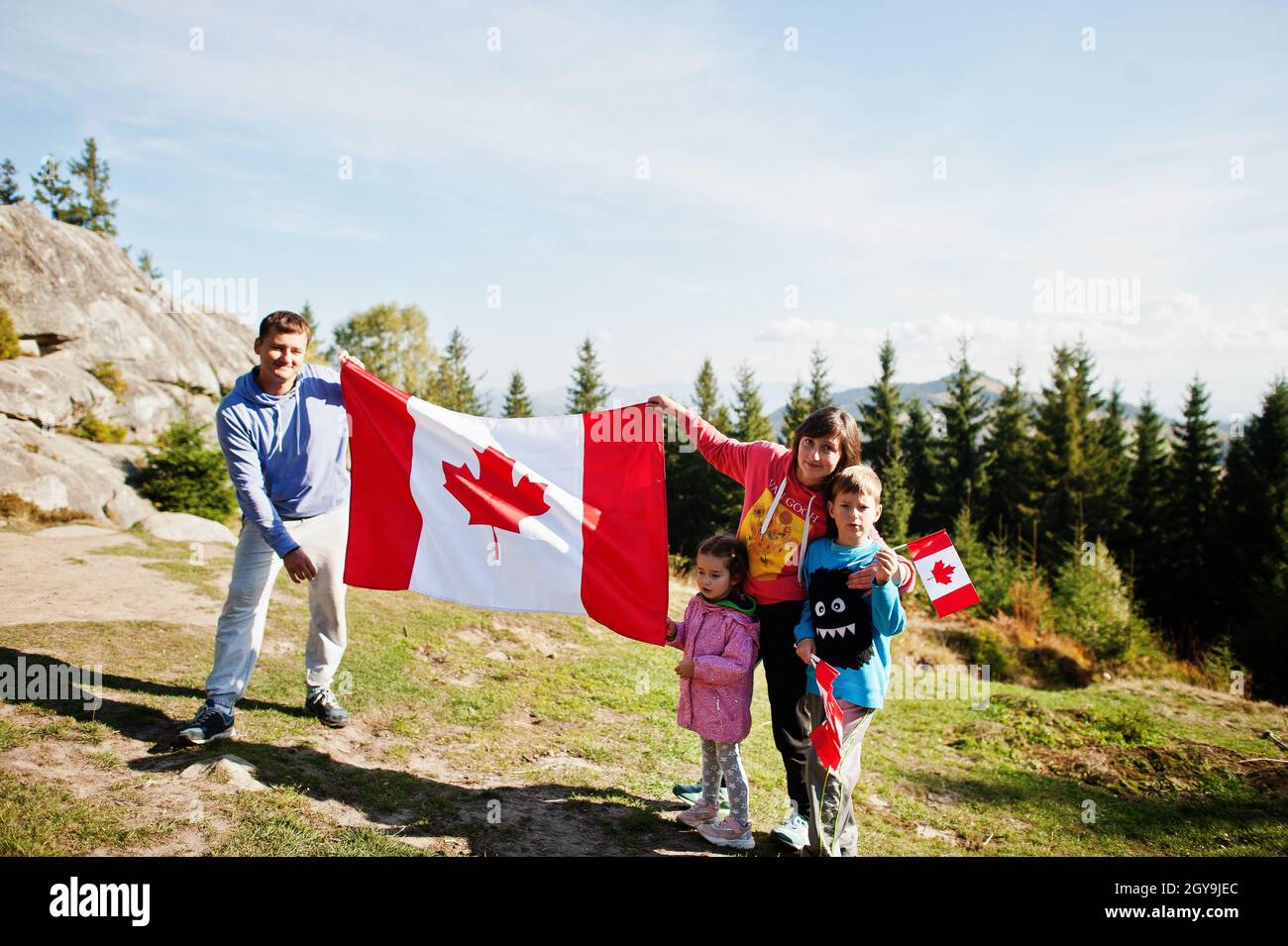 Happy Canada Day. Family with large Canadian flag celebration in ...