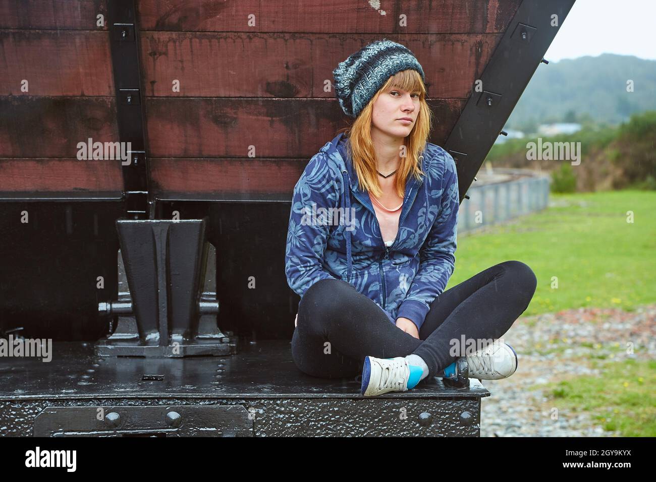 Young woman sitting on a train wagon in rainy weather Stock Photo - Alamy