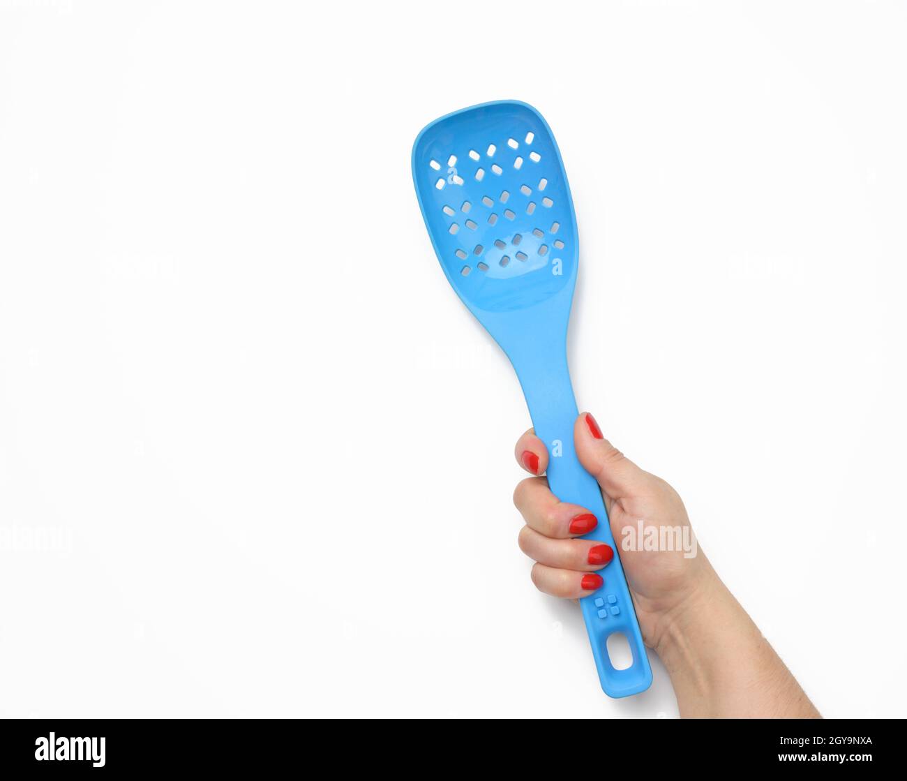 female hand holding a blue plastic spatula with holes on a white ...