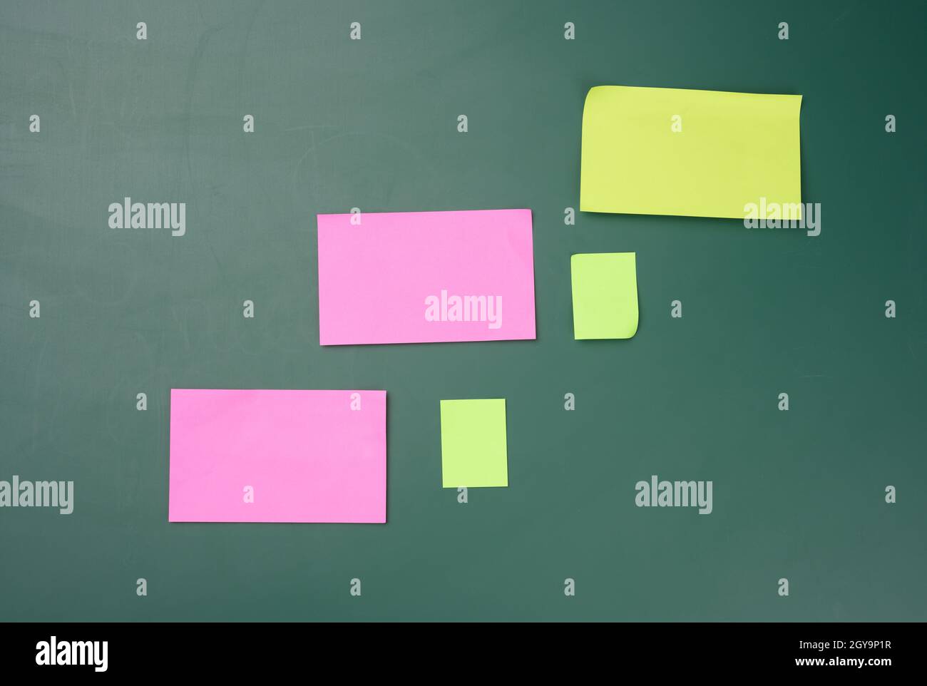 multicolored paper sticks are glued to the green board, copy space ...