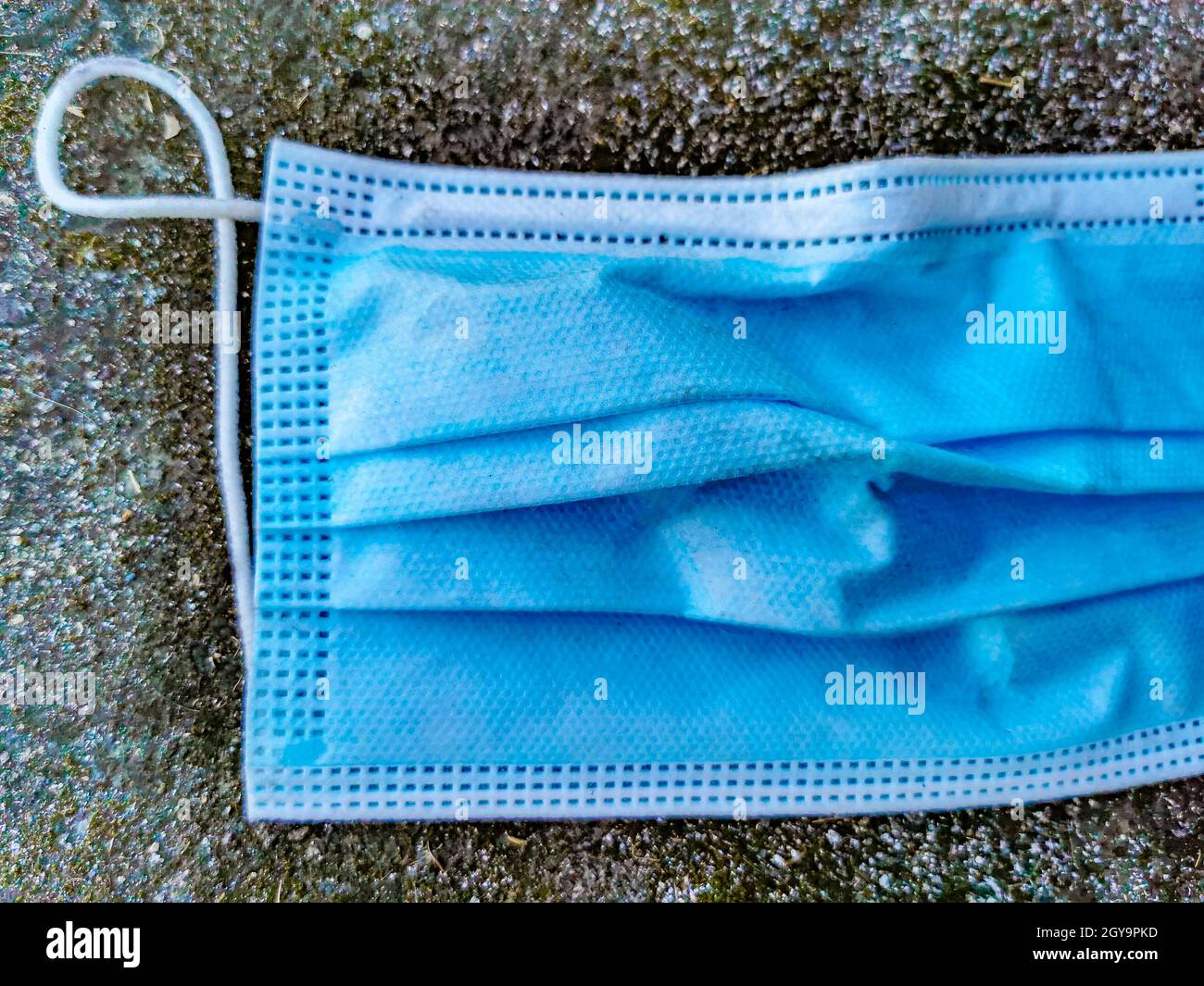 Dirty surgical blue masks on the ground. Corona virus pollution ...