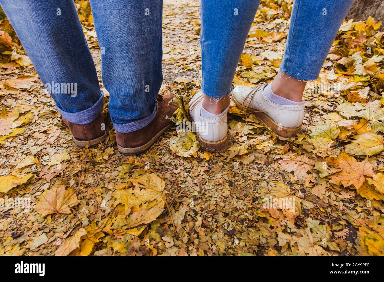 Womans and mans boots on dry fall leaves in the nature park outdoor and ...