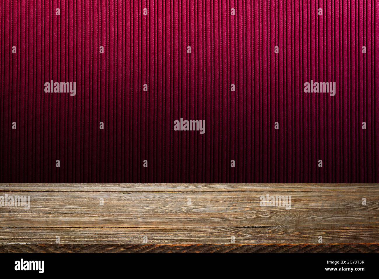 The background is blank wooden boards and a textured striped wall with ...