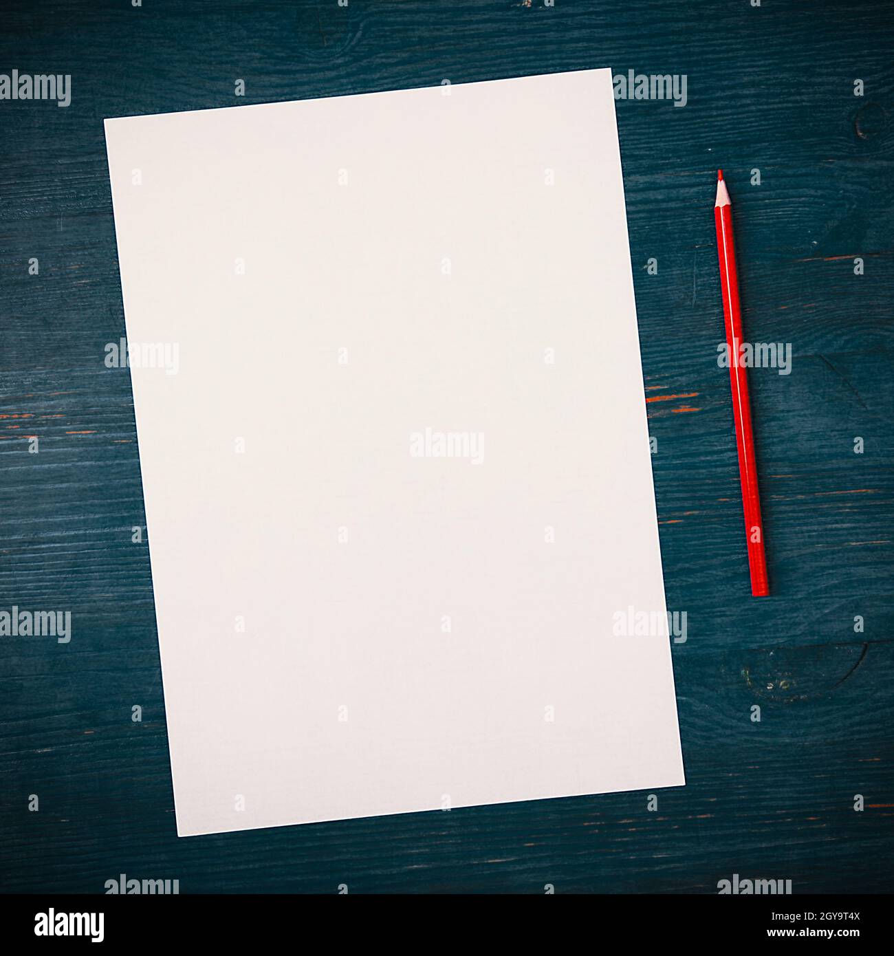 A blank white sheet and pencil for drawing on a wooden background with ...