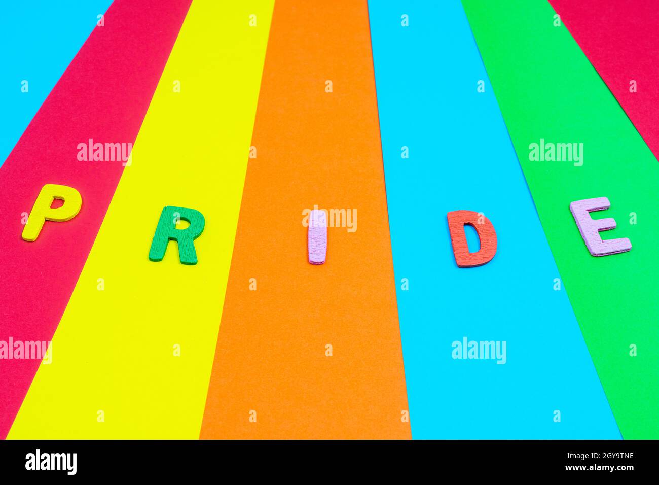 the word Pride on a surface with some colored stripes to form a rainbow ...
