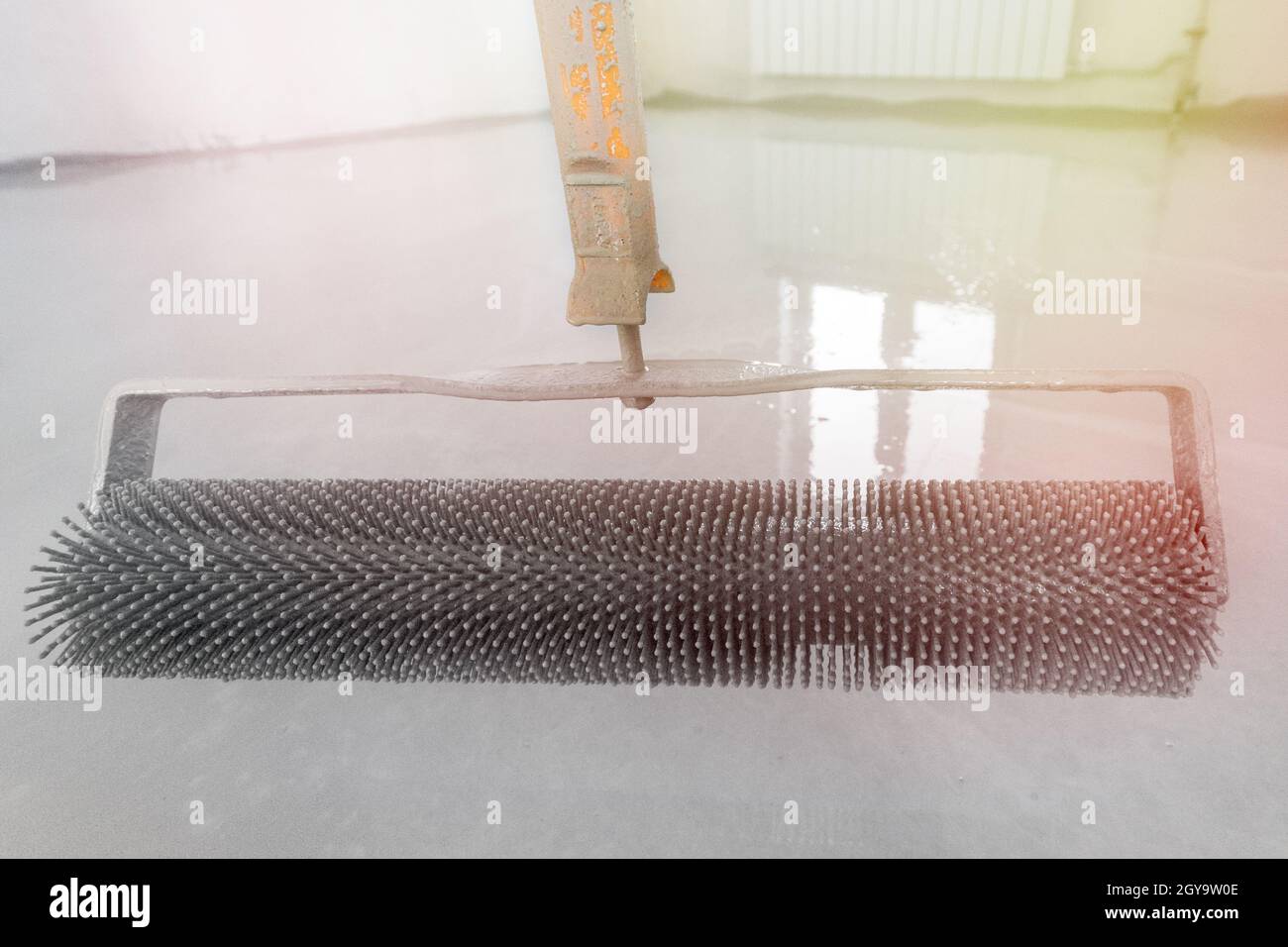 Close-up spiked roller leveling tool for self-leveling floor. Lens ...