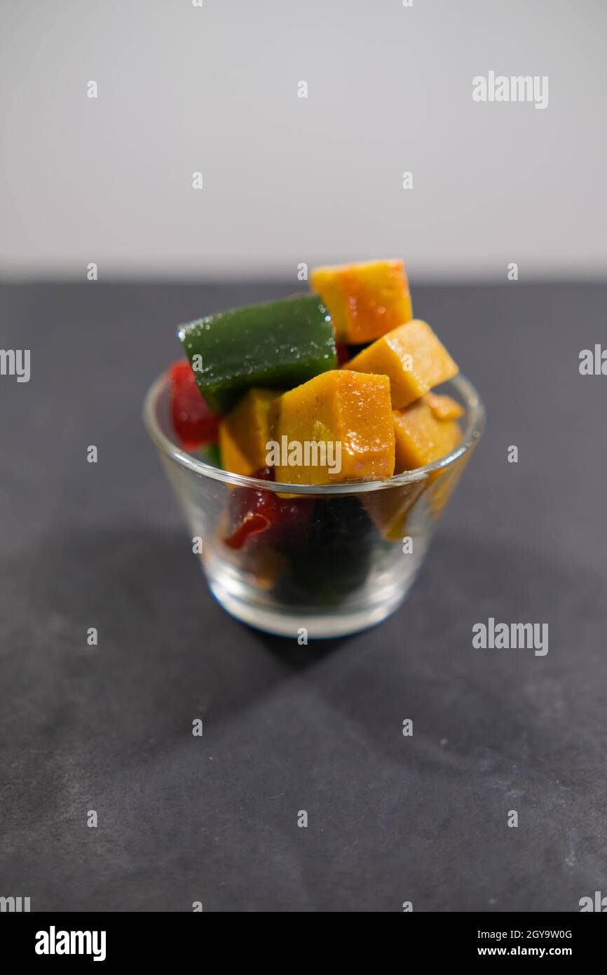 Glass of colorful Mexican fruit paste slices on black surface Stock ...
