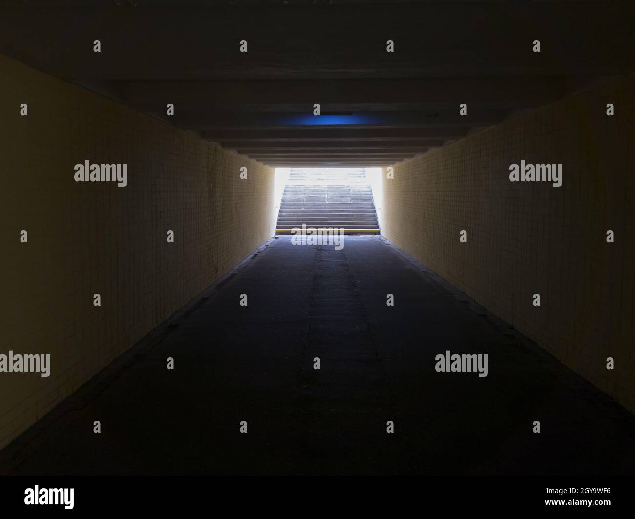 Empty yellow underground pedestrian crossing. Tunnel and daylight at ...