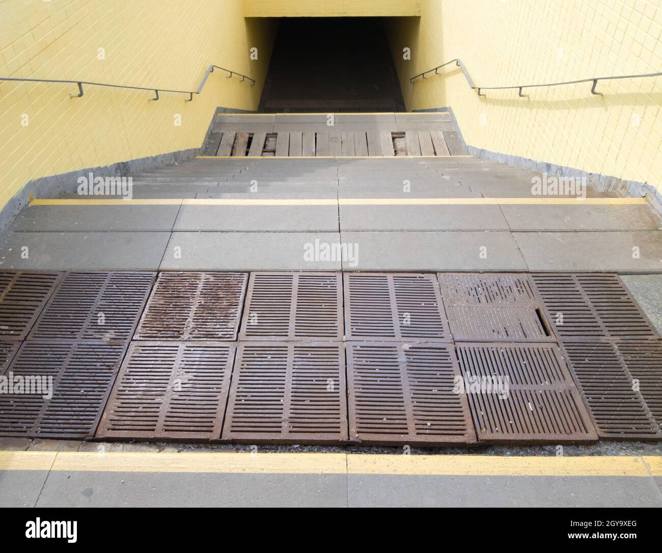 Empty yellow underground pedestrian crossing. Tunnel and daylight at ...