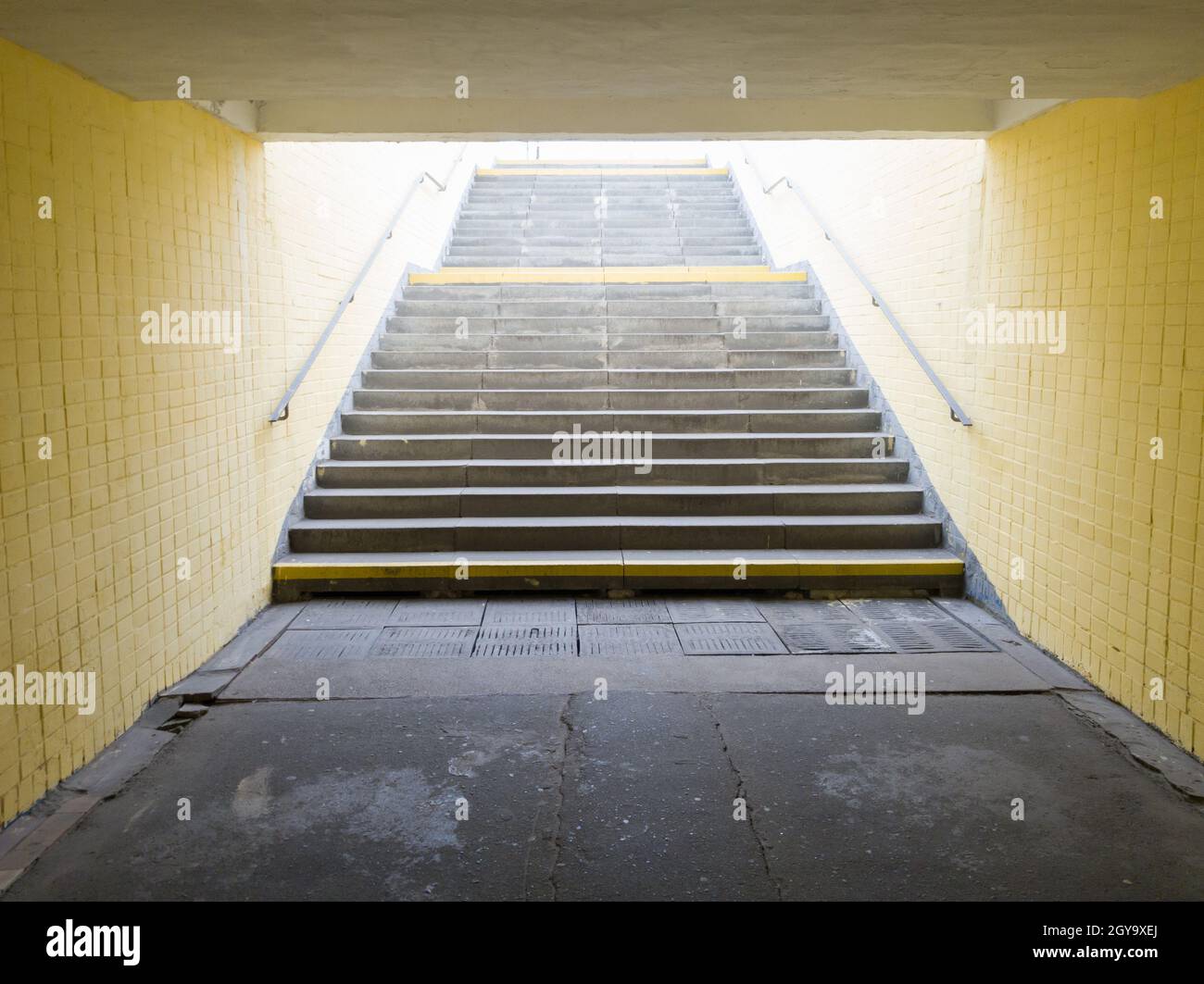 Empty yellow underground pedestrian crossing. Tunnel and daylight at ...