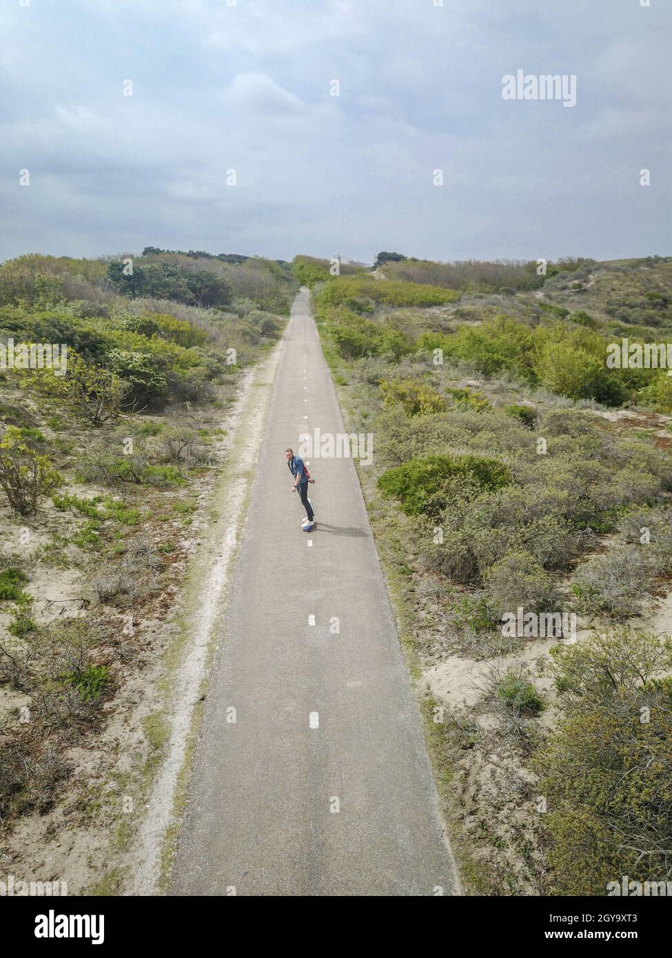 Drone View of an isolated man skating a Countryside straight road Stock ...