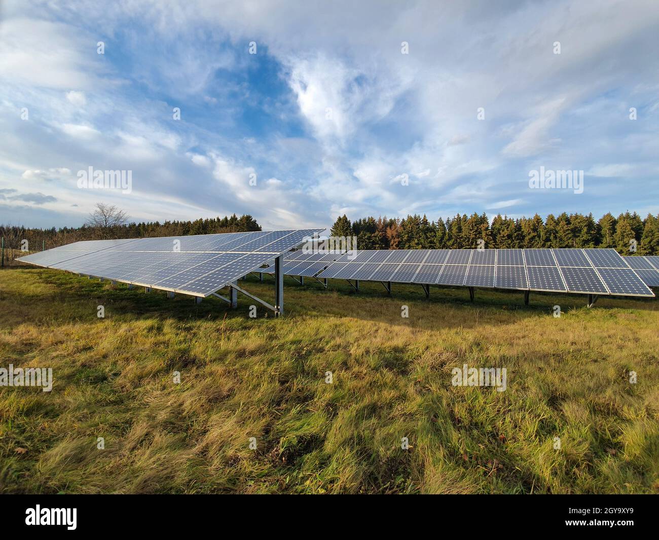 Solar cells on a meadow with blue sky with clouds. Solar panels ...