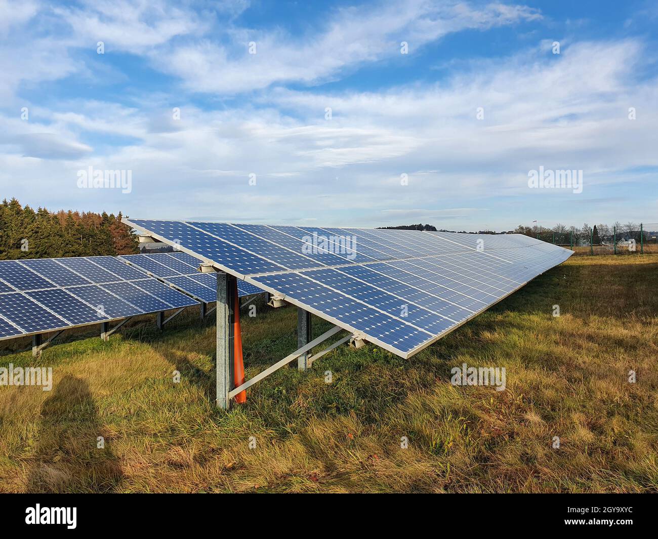 Solar cells on a meadow with blue sky with clouds. Solar panels ...