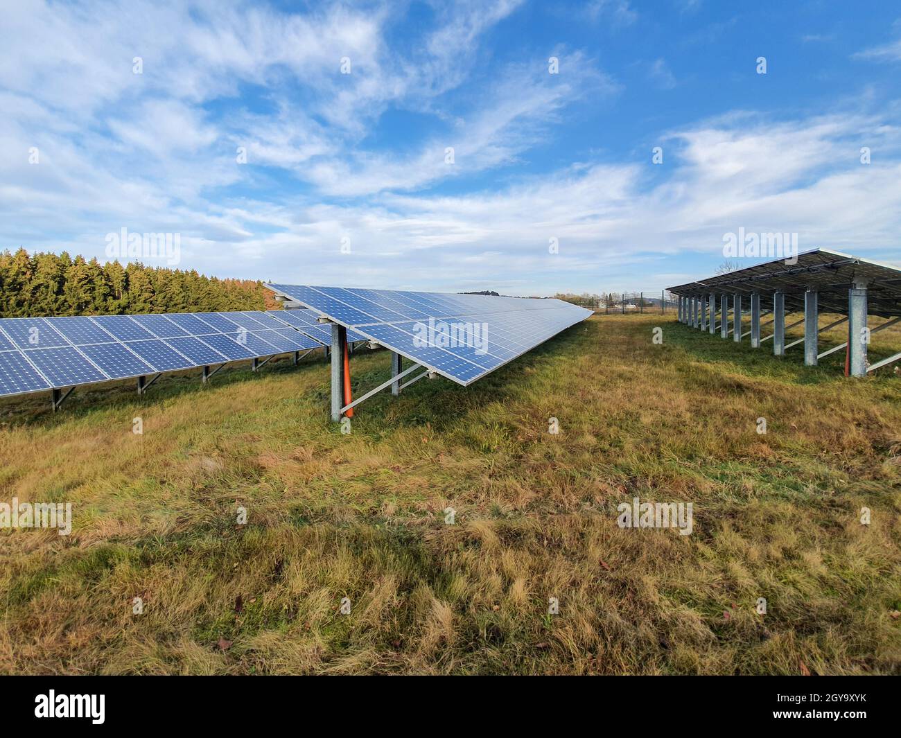 Solar cells on a meadow with blue sky with clouds. Solar panels ...