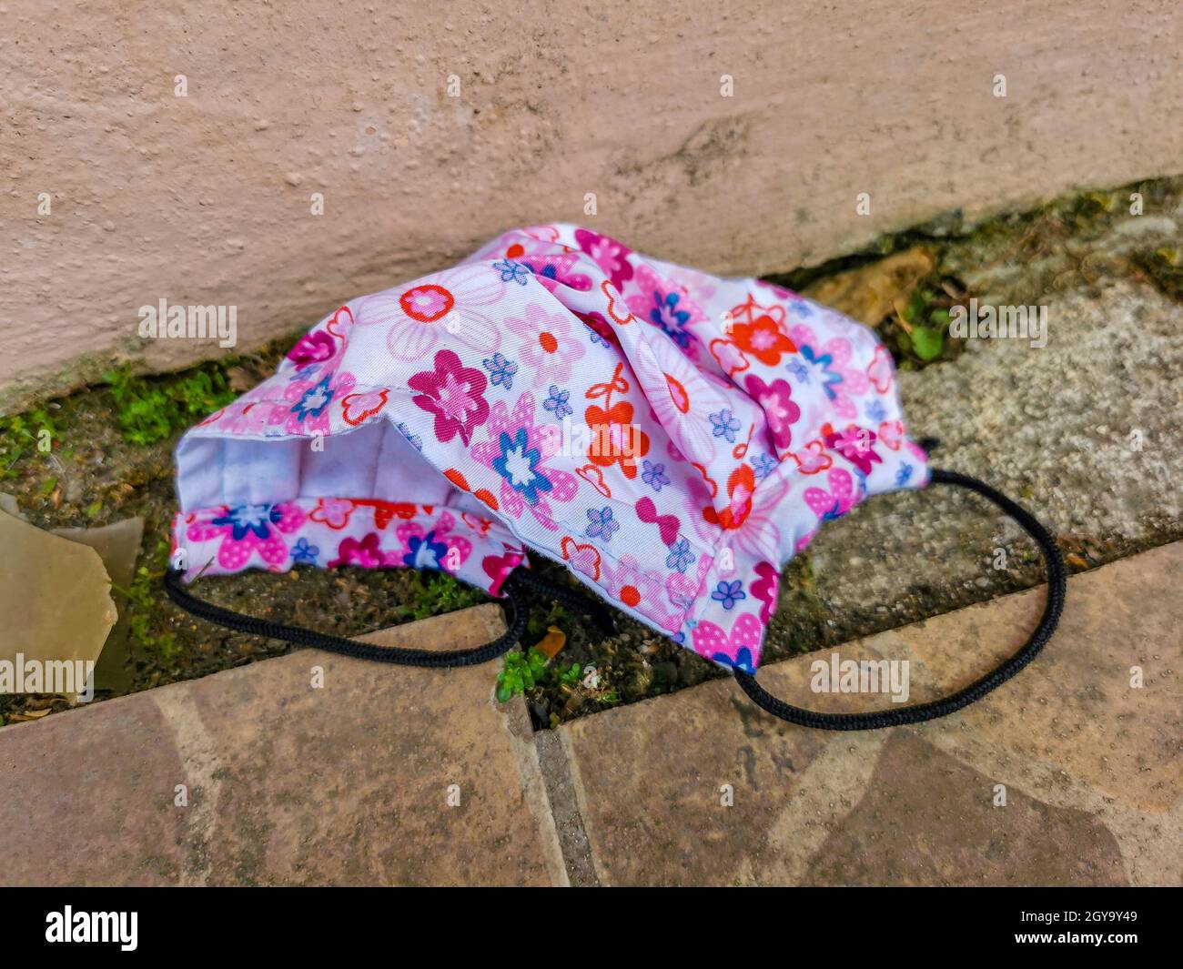 Dirty surgical pink masks with flowers on the ground. Corona virus ...