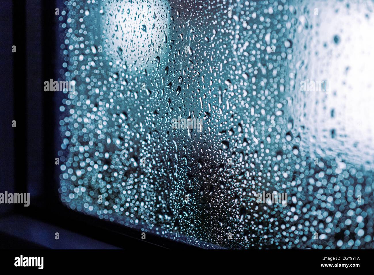 Close up of rain drops on the window in rainy night, cool lights and ...