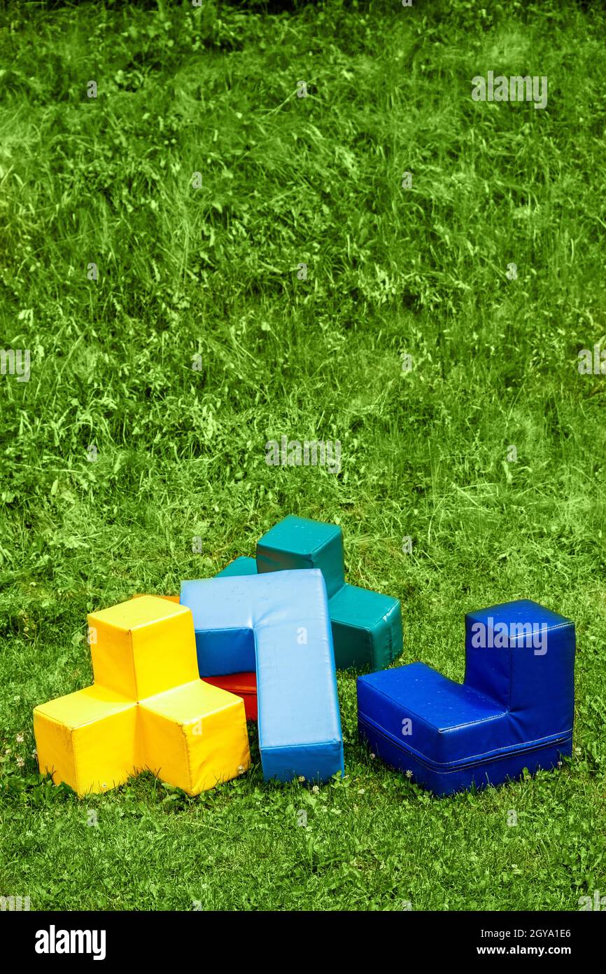 Soft colorful huge tetris cubes on green lawn. Outdoor teambuilding ...