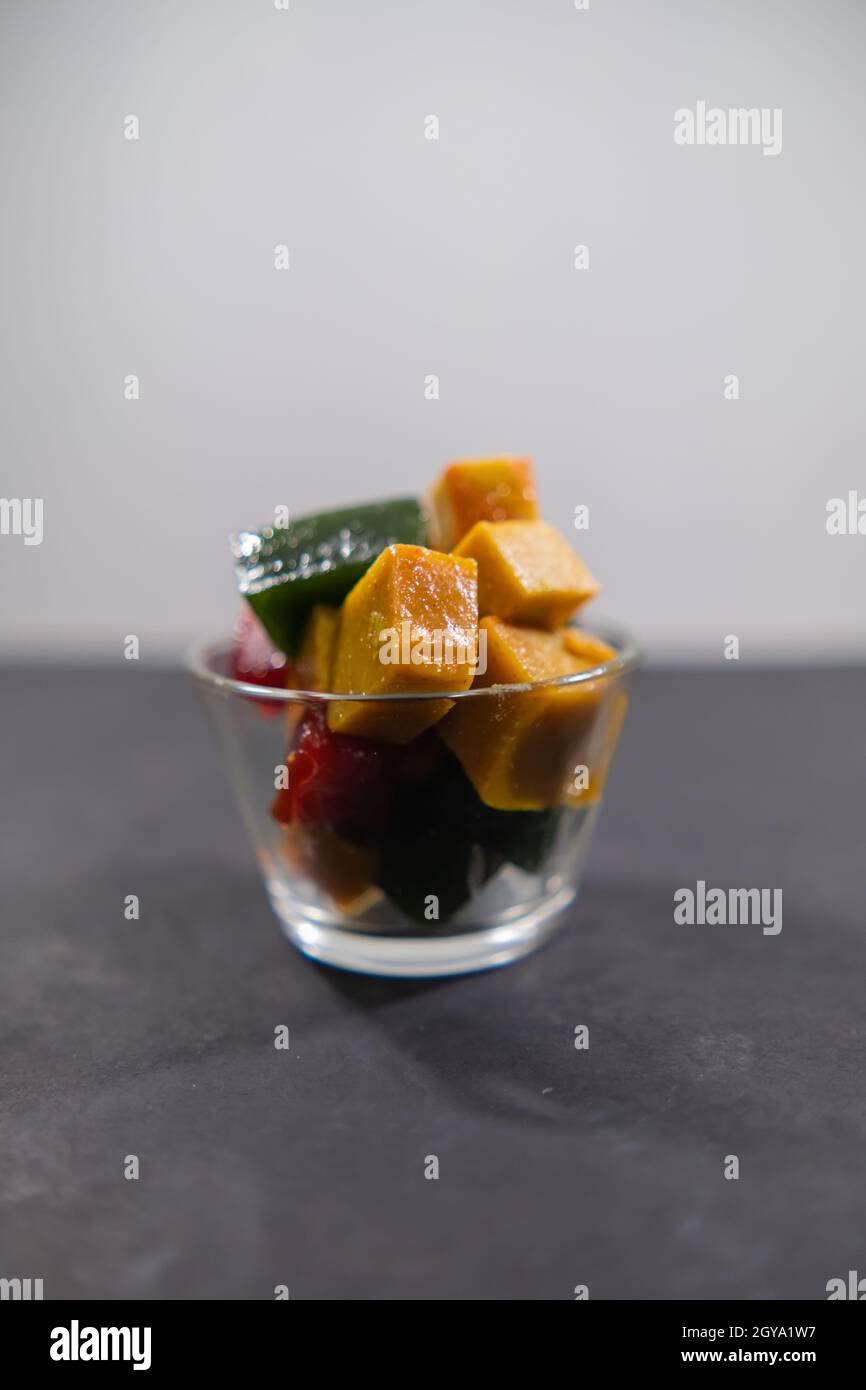 Glass of colorful Mexican fruit paste slices on black surface Stock ...