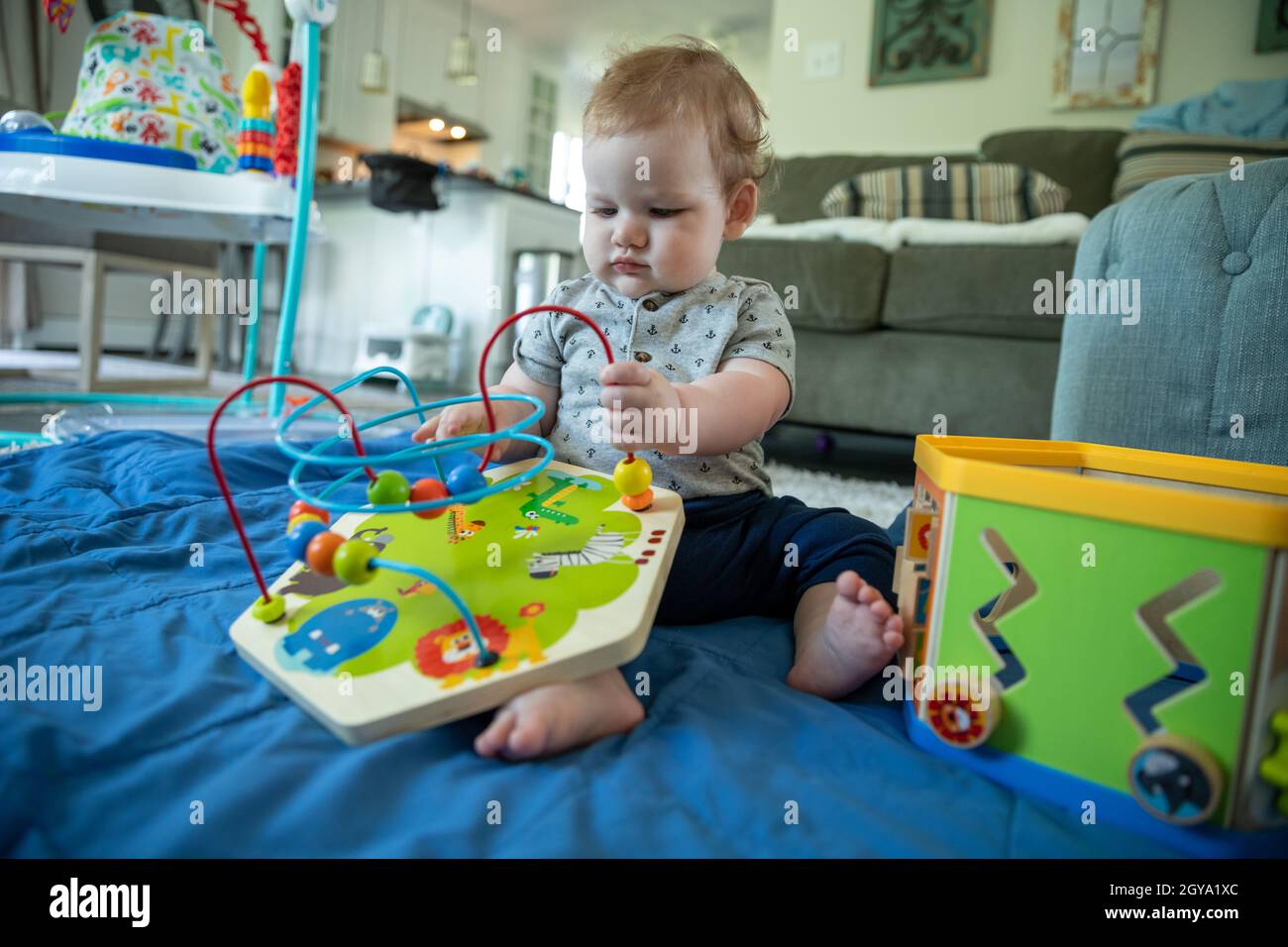 Curious baby boy playing alone with toys Stock Photo - Alamy