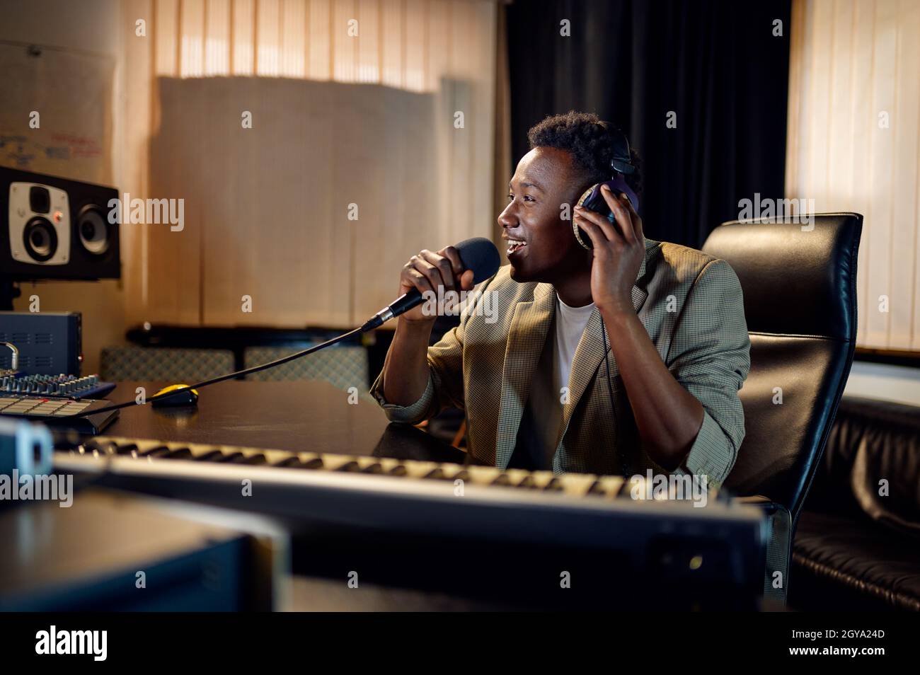 Sound engineer in headphones holds microphone, recording studio ...