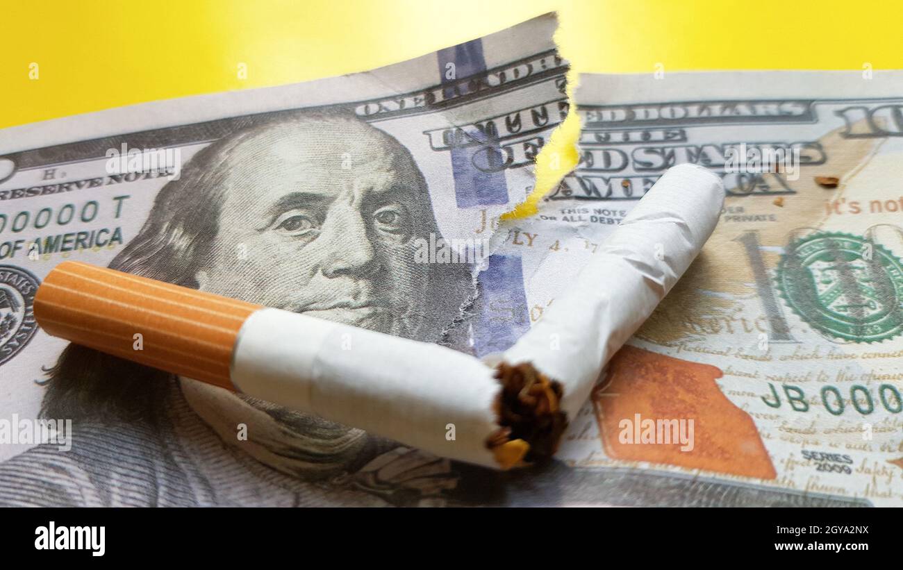 Classic cigarettes stand on one hundred US dollar bills. Cigarettes on ...