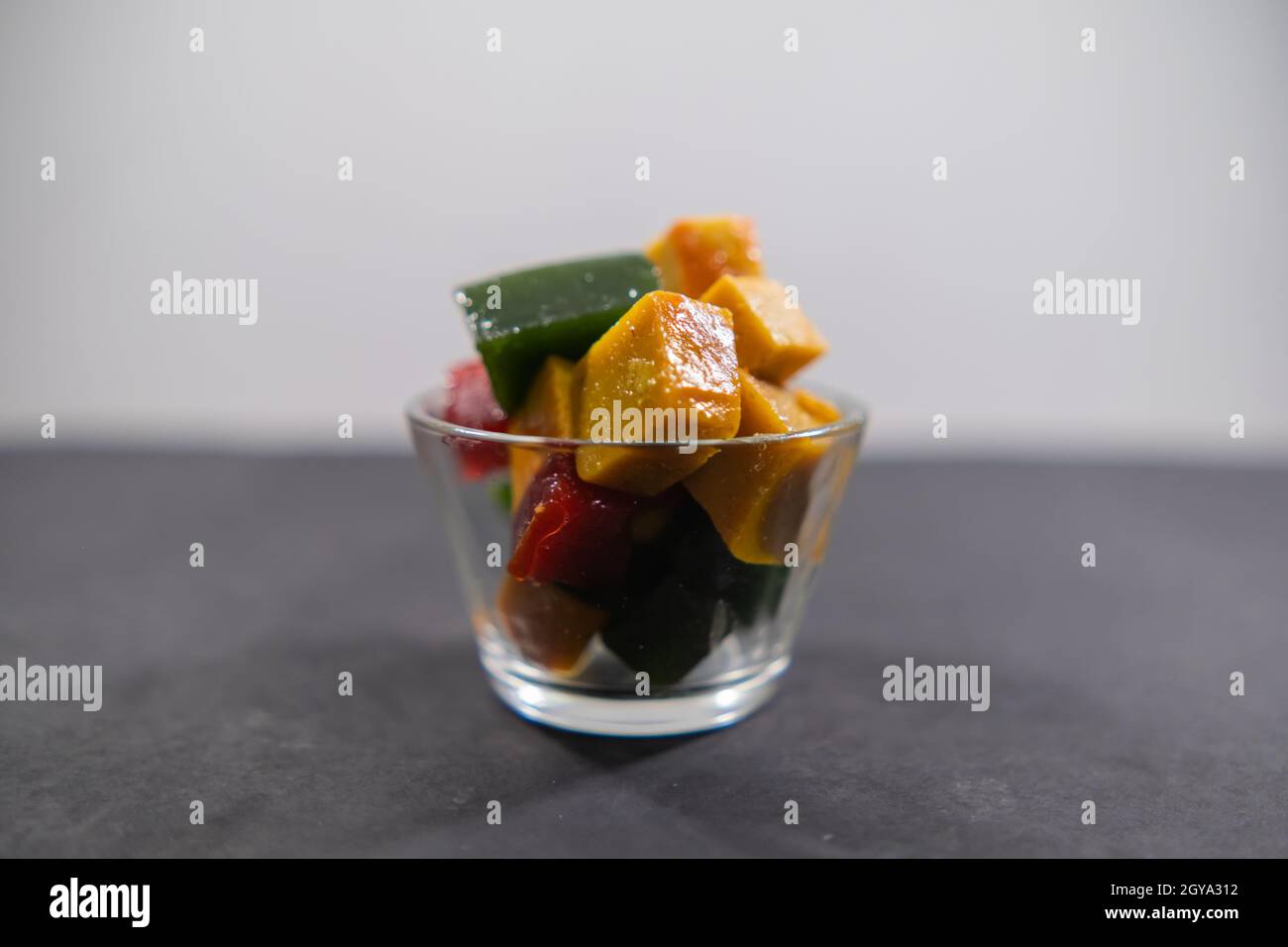 Glass of colorful Mexican fruit paste slices on black surface Stock ...